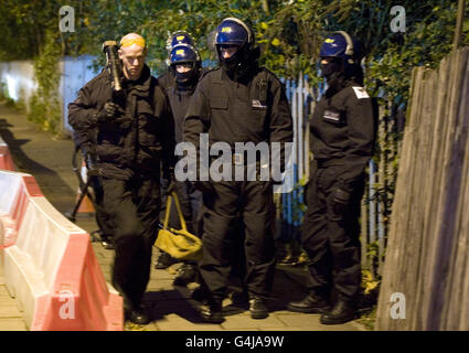 Police officers prepare to raid an address in Peckham, south London ...