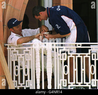 England captain Nasser Hussain gets treatment from the England trainer ...