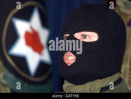 A masked member of the loyalist UFF (Ulster Freedom Fighters) attends a ...