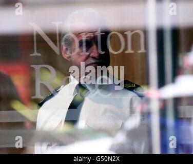 A security guard keeps watch at News International in Wapping, London ...