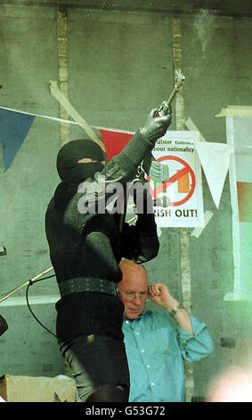 A masked member of the Ulster Freedom Fighters (UFF) fires a volley of ...