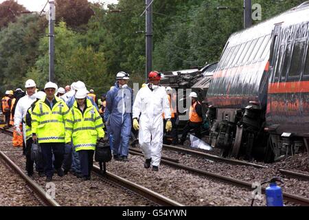 Rail crash investigators pick their way through the wreckage of the ...