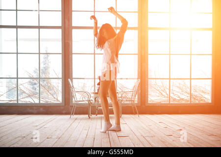 Attractive young woman dancing near huge windows Stock Photo - Alamy