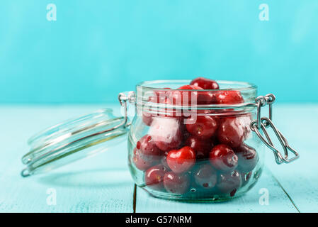 Jar Of Red Fresh Cherries On Turquoise Background Stock Photo - Alamy
