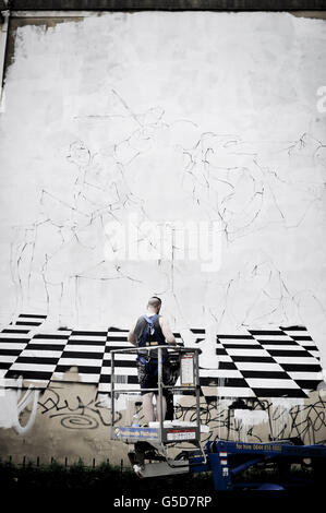 STANDALONE PHOTO An artist rides on a cherry picker as he begins a huge ...