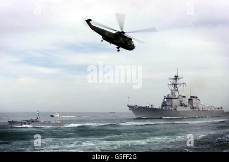 Royal Naval Lieutenant Angus Essenhigh takes a bearing on the bridge of ...