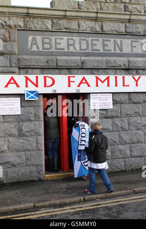 Fans go through the turnstiles at Pittodrie Stadium home of Aberdeen ...