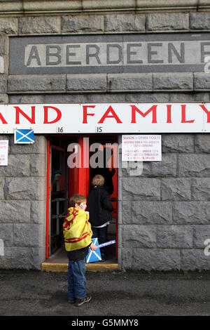 Fans go through the turnstiles at Pittodrie Stadium home of Aberdeen ...