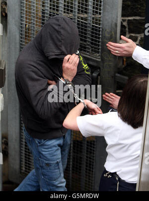 Paul James Manolito Toland hides his face as he is remanded into ...