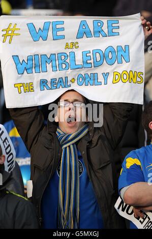 A Milton Keynes Dons fan holds up a Wimbledon & MK Dons scarf in the stands Stock Photo - Alamy