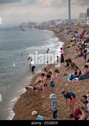 Crowds on busy Brighton beach as sun goes down Stock Photo - Alamy