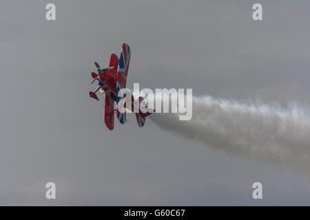 Pitts Special S2S biplane doing aerobatics in the sky with smoke trails ...