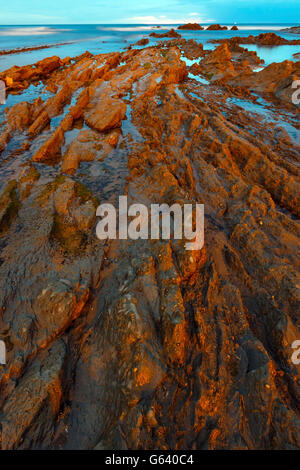 Twilight ocean coast with ribbed stratiform rock formations. (Atlantic ...