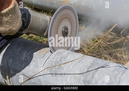 Work sawing asbestos pipe for foundation electric tool Stock Photo - Alamy