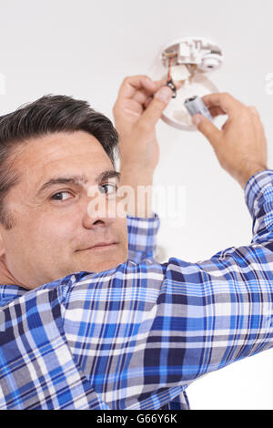 Man changing battery in smoke detector Stock Photo - Alamy
