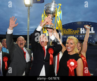 Co-Owner, Simon Wooder (centre) lifts the William Hill Derby trophy ...