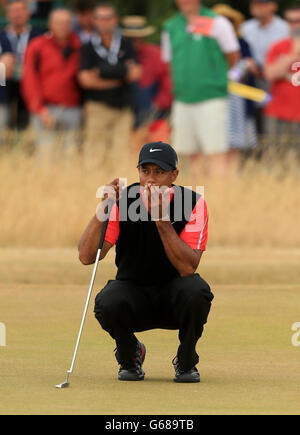 Tiger Woods lines up a putt on the 18th green during the first round of ...