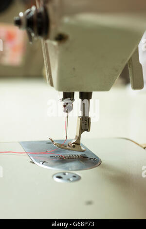 Needle threaded with red thread Stock Photo - Alamy