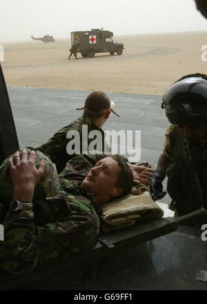 A british soldier clutches his helmet as he is medically evacuated from ...