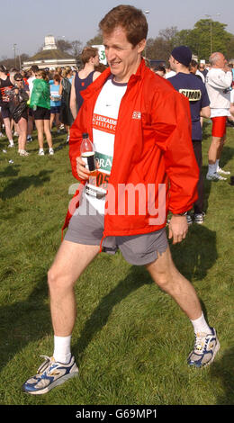 President George Bush stretches on a fence rail before jogging near his ...
