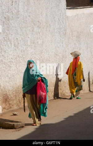 Harari women walking in the street wearing colourful clothing. Harar ...
