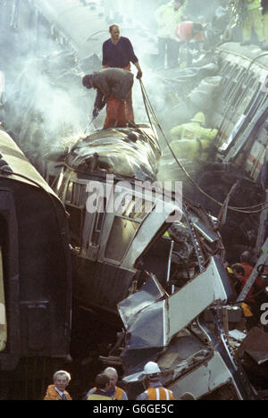 Rescue workers clamber over the wreckage of three trains that crashed ...