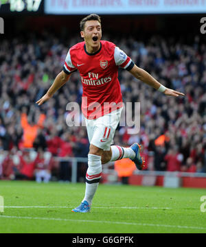 Mesut Ozil of Arsenal celebrates scoring his goal to make it 3-0 during ...