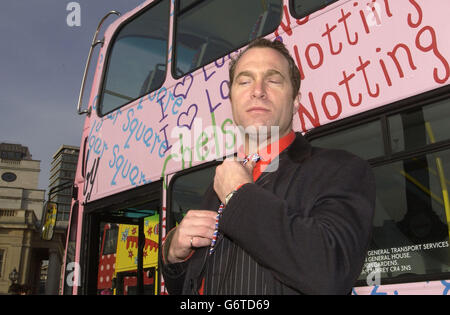 Fashion designer Toby Mott poses for photographers in a London bus ...