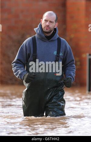 Christian Gander makes his way through floodwater as he leaves his home ...
