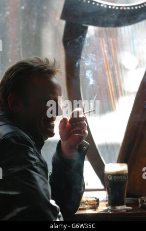 Two men smoking in The Oval Bar on Middle Abbey Street, Dublin, Ireland ...