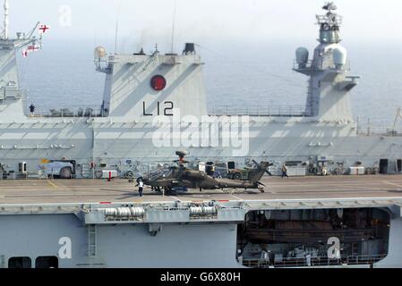 An Apache attack helicopter is prepared for flight aboard HMS Ocean in ...