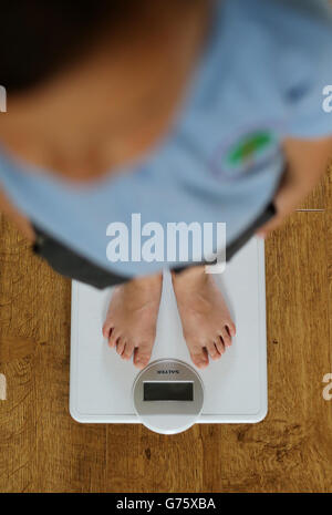 Child being weighed. A young child is weighed on scales Stock Photo - Alamy