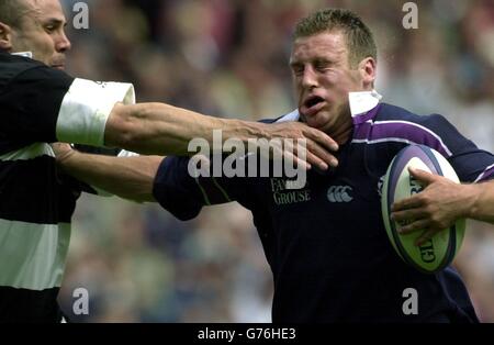 Scotland's Brendan Laney holds off Barbarian Peter Muller, watched by ...