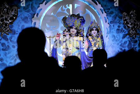 Hare Krishna devotees look up at an image of Lord Krishna and his ...