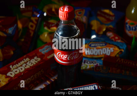 A bottle of Coca Cola with biscuits, crisps, chocolate bars and ...