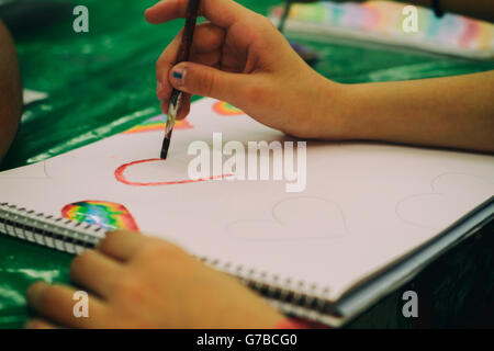 Photograph of a hand with a paintbrush painting hearts Stock Photo - Alamy