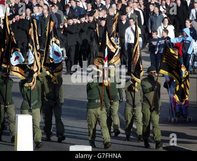 A masked Ulster Defence Association (UDA) colour party leads hundreds ...