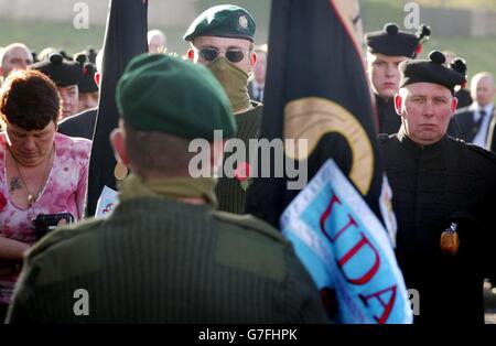 A masked member of the Ulster Defence Association (UDA) colour party at ...