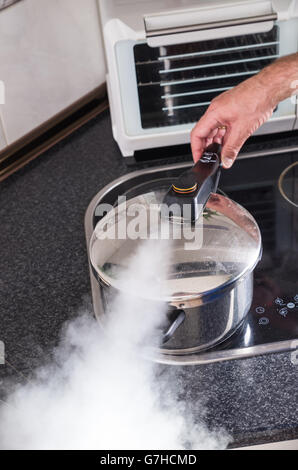 Steam releasing from the pressure cooker (vertical Stock Photo - Alamy