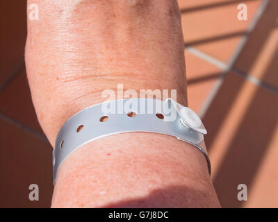 All-inclusive armband on a female wrist , sunny holiday, glass of white ...