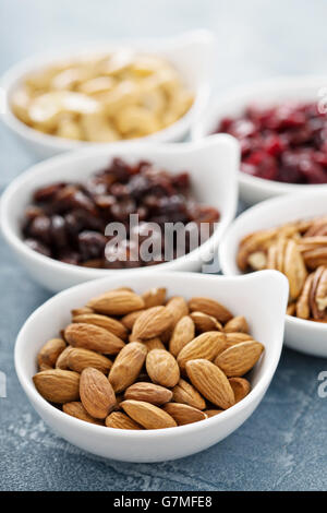 Dried fruits and Nuts in bowls on white background, top view. Healthy snack - assortment of ...