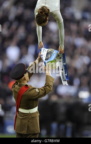 A high wire trapeze artist delivers the Capital One Cup before kick off ...
