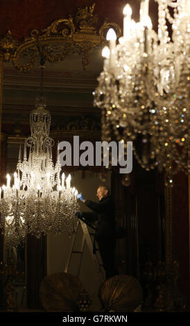 Conservator Robin Matthews removes the dust from a chandelier at ...