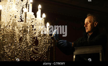 Conservator Robin Matthews removes the dust from a chandelier at ...