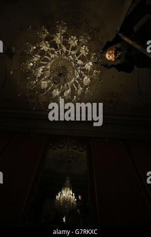 Conservator Robin Matthews removes the dust from a chandelier at ...