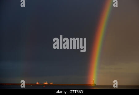 A rainbow appears over the lighthouse at Tynemouth this evening as the ...