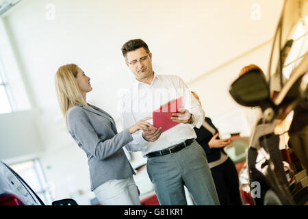 Elegant salesperson working at car dealership Stock Photo - Alamy