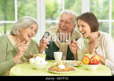 daughter with senior parents drinkig tea Stock Photo - Alamy