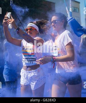 Volunteers throw colourful powder on runners during the Color Run at ...