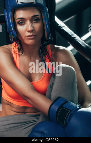 Tired young boxer sitting at corner in boxing ring Stock Photo - Alamy